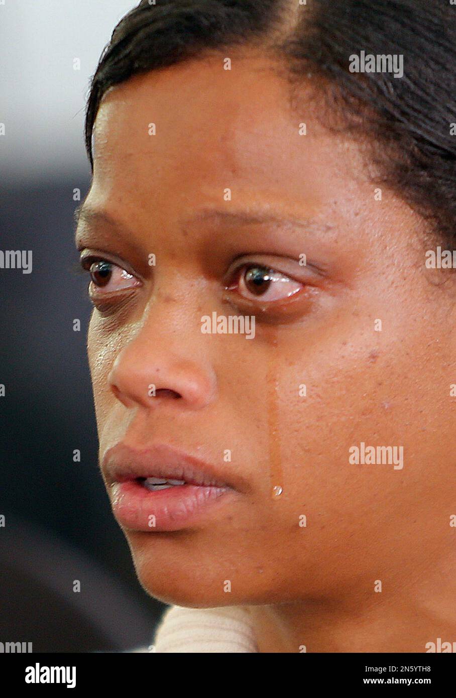 A woman cries while watching the funeral of former South African ...