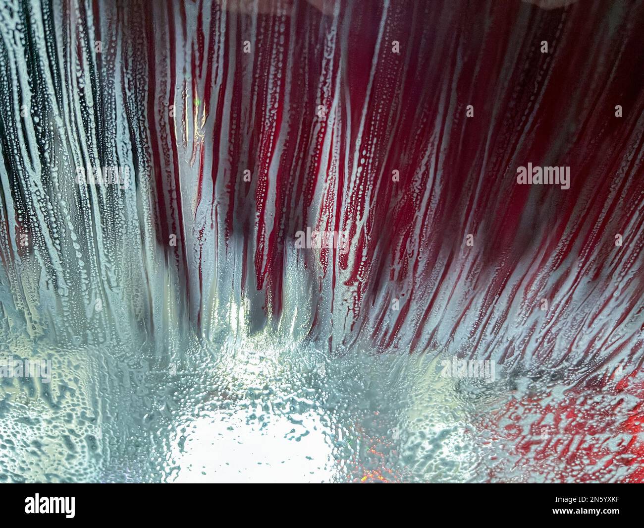 Abstract texture view of a car windshield in an automatic car wash ...