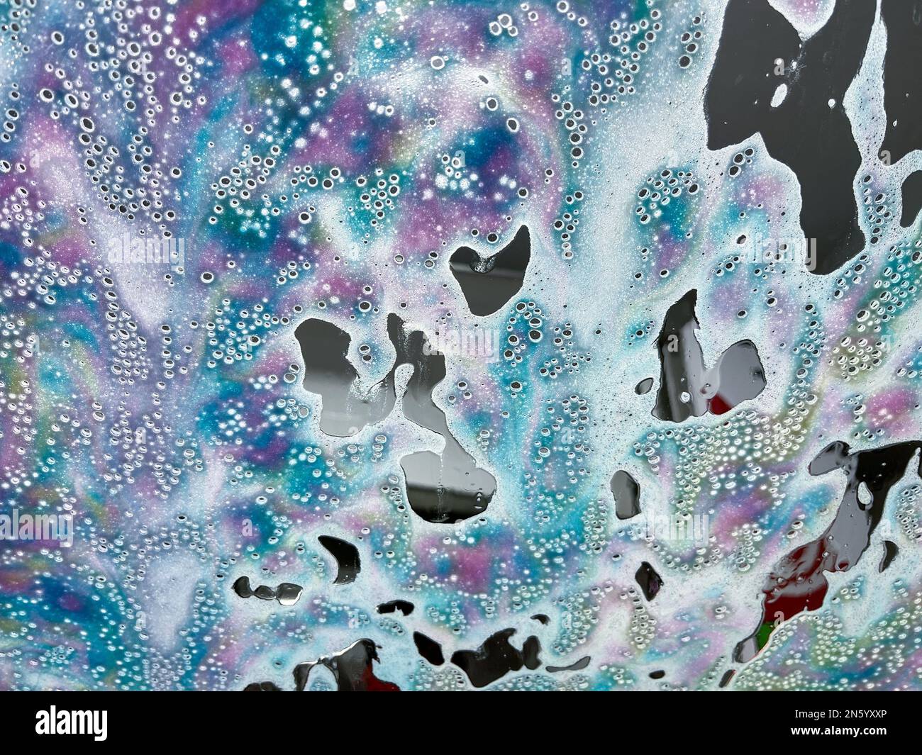 Abstract texture view of a car windshield in an automatic car wash ...