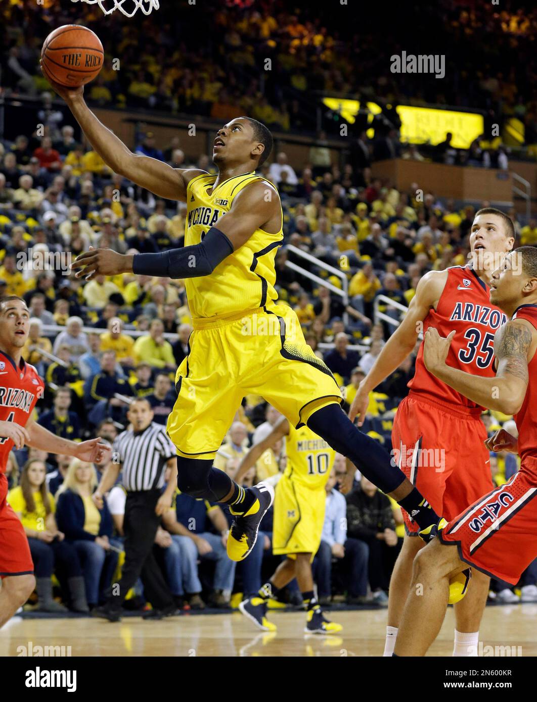 Michigan forward Glenn Robinson III makes a layup as Arizona center ...