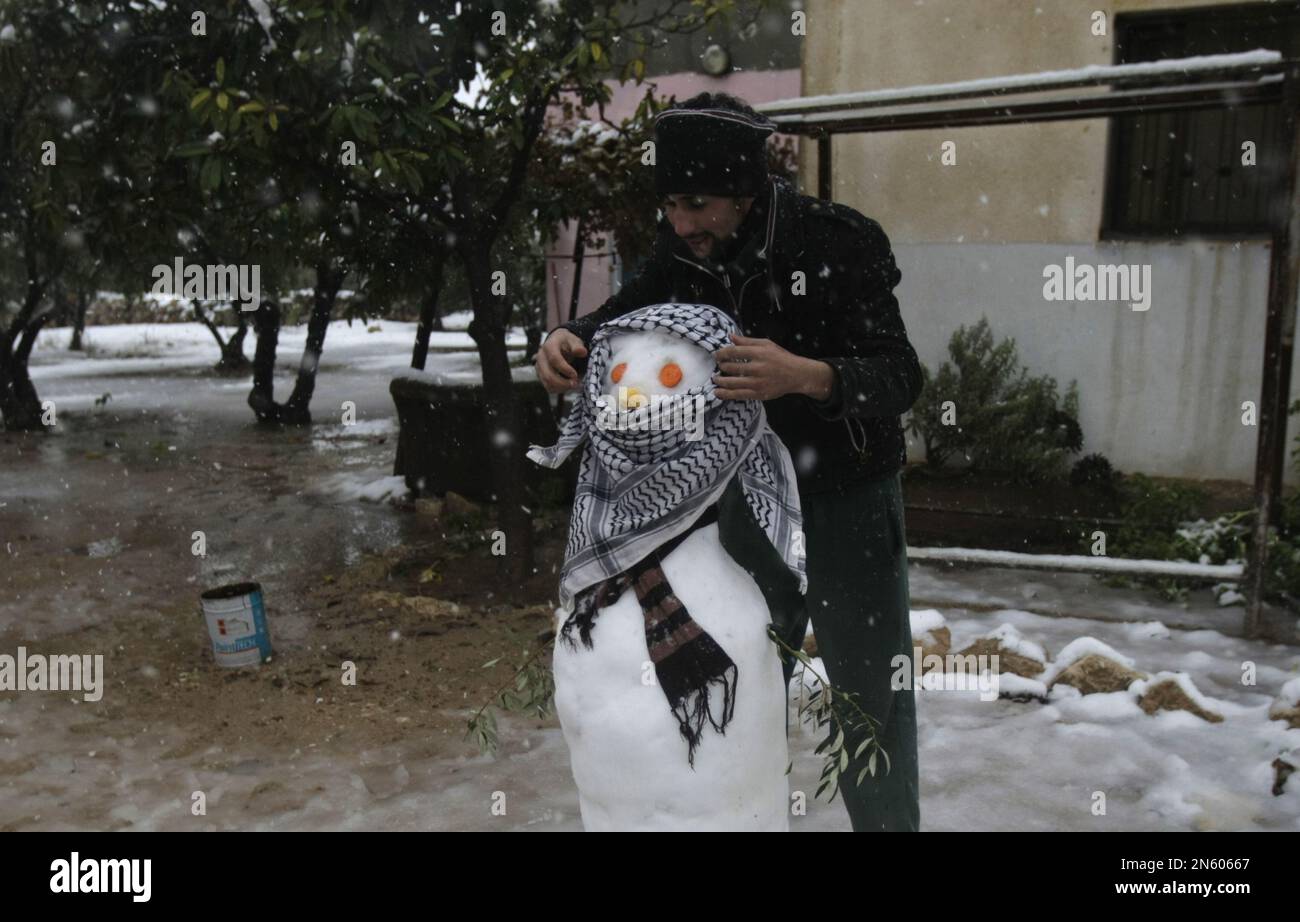A Palestinian youth makes a snowman in the West Bank town of Nablus ...