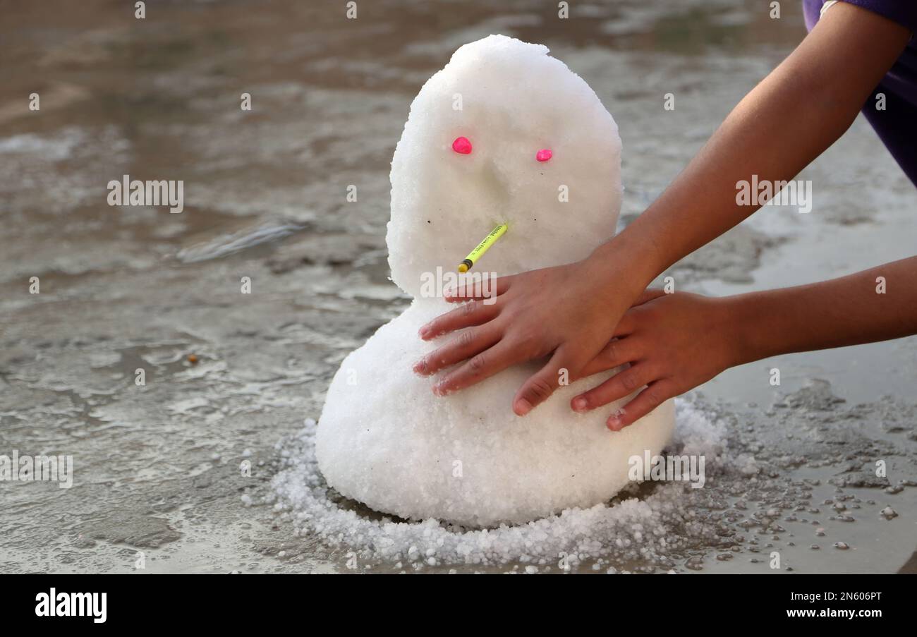 A Palestinian child makes a snowman in Gaza City, Friday, Dec. 13, 2013 ...