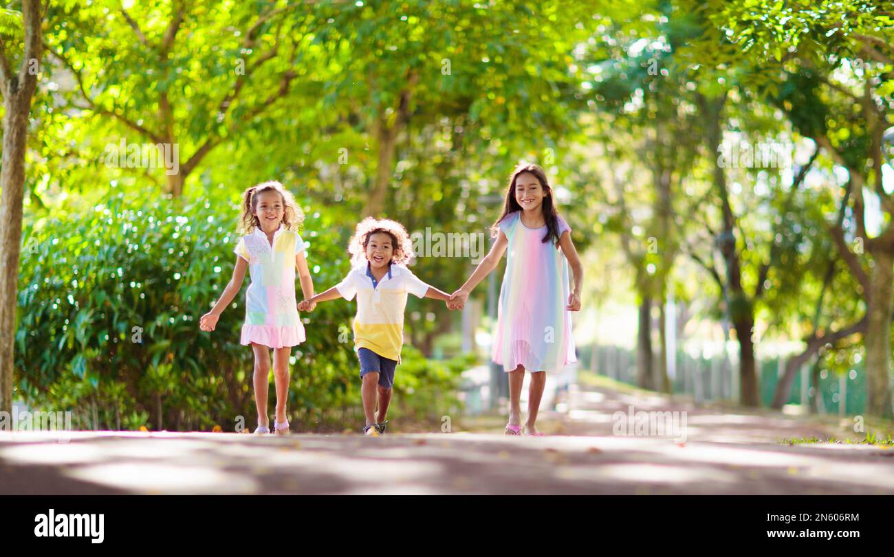 Happy kids play in summer park. Children run and laugh. Summer vacation ...