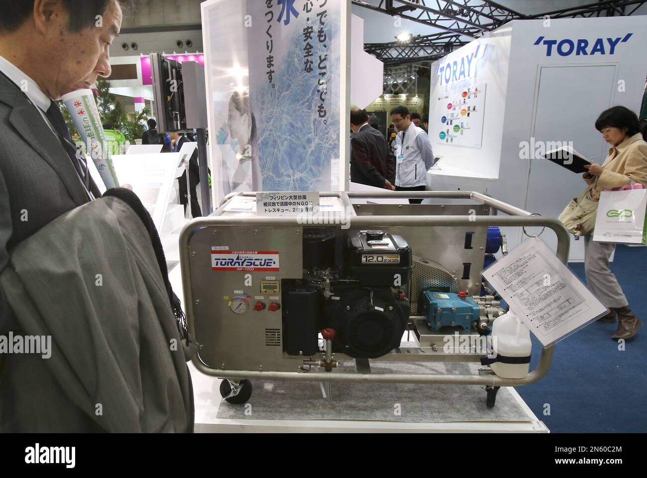A man looks at a portable fresh water generator named TORAYSCUE ...