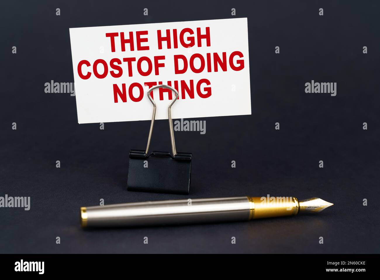 Business concept. On the black surface is a pen, an office paper clip ...