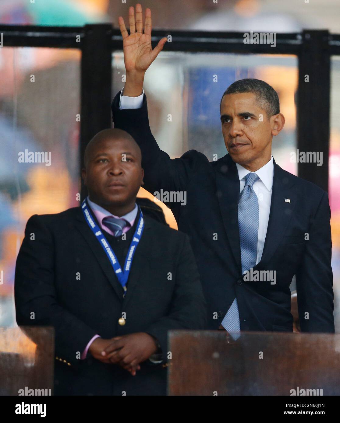 President Barack Obama waves standing next to the sign language ...