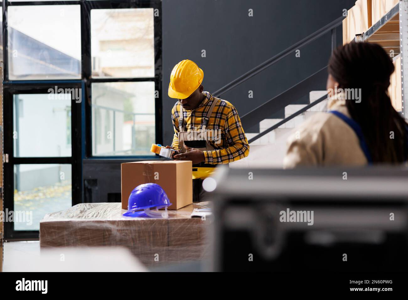 African american man packing customer package in postal warehouse ...