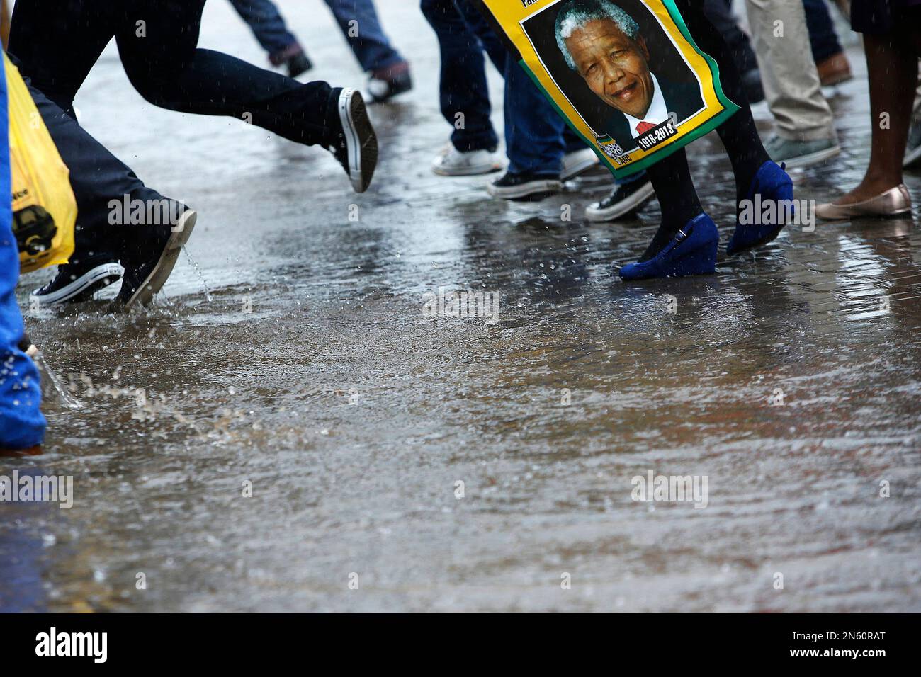 People run through the rain as they arrive for the memorial service for ...