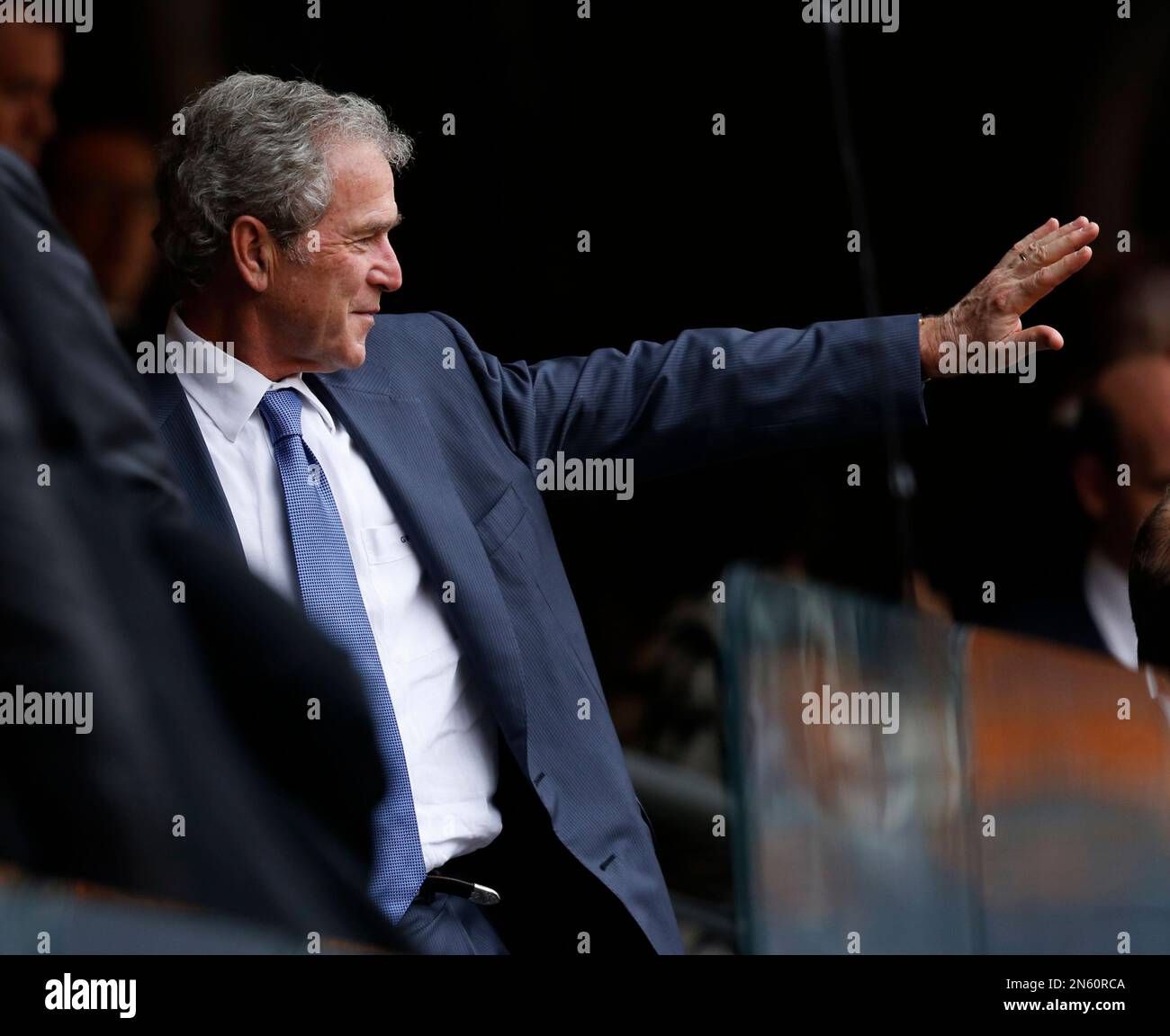 Former U.S. President George W. Bush waves during the memorial service ...