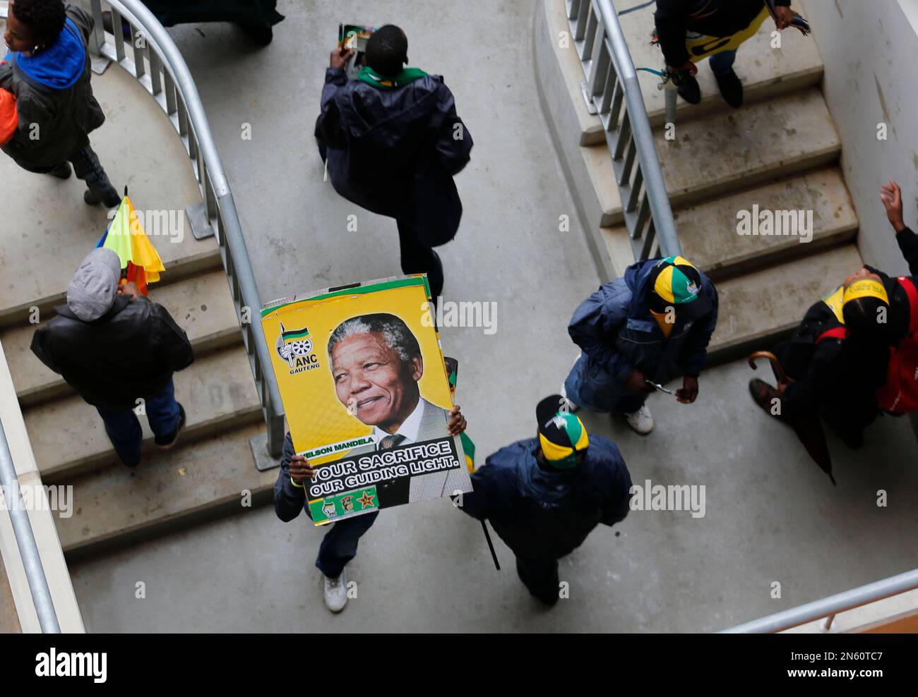 A man carries a poster as he arrives for the memorial service for ...