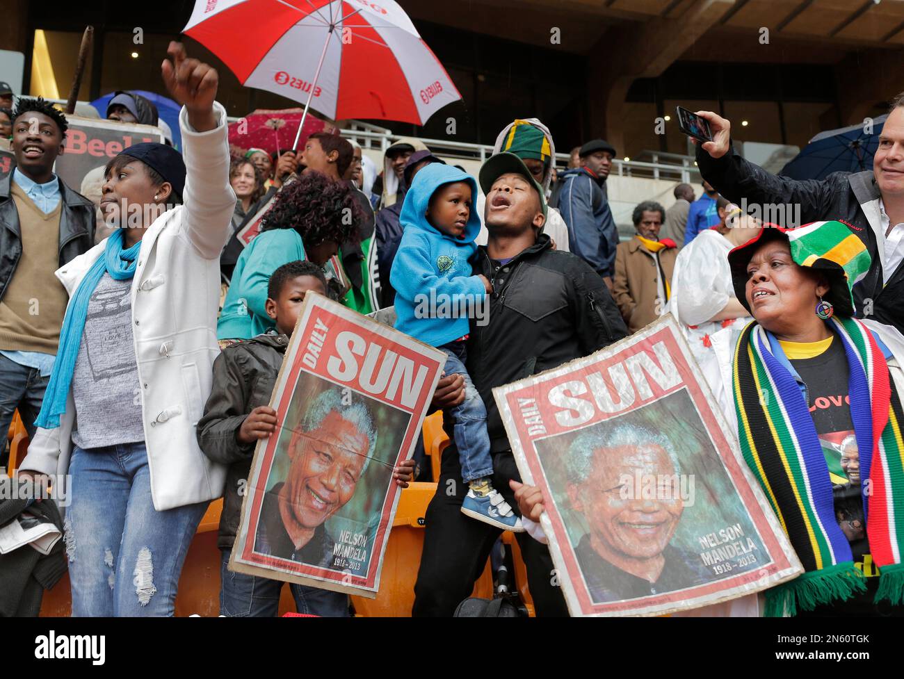 People hold images of former South African president Nelson Mandela ...