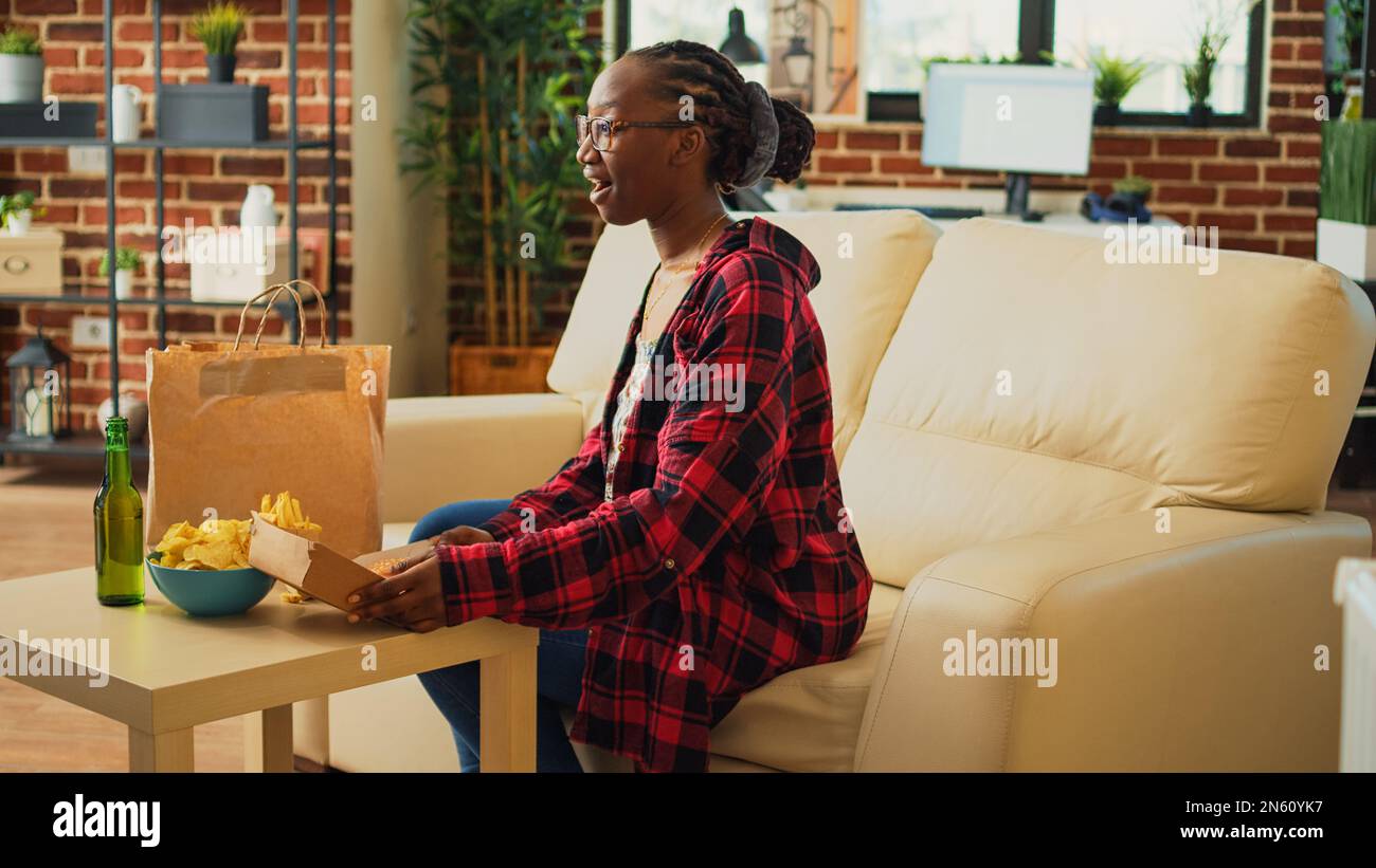Young adult taking out hamburger and fries, eating fast food takeaway ...