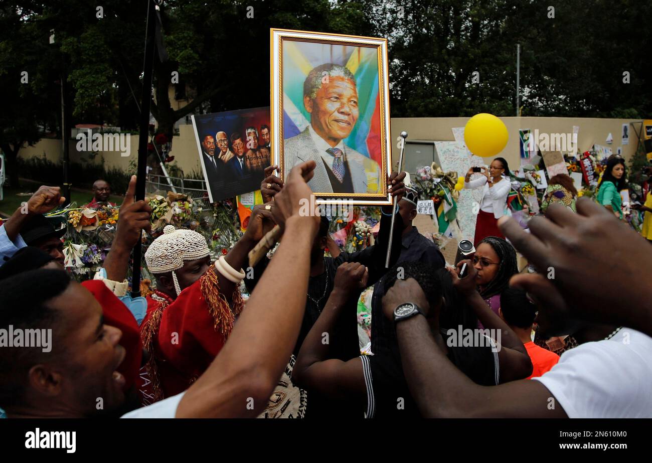 Mourners from Nigeria, sing outside the home of former president Nelson ...