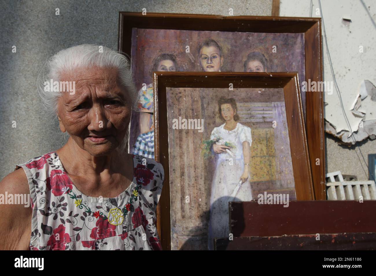 Typhoon survivor Lotilda Salvana, 89, poses beside a painting of her ...