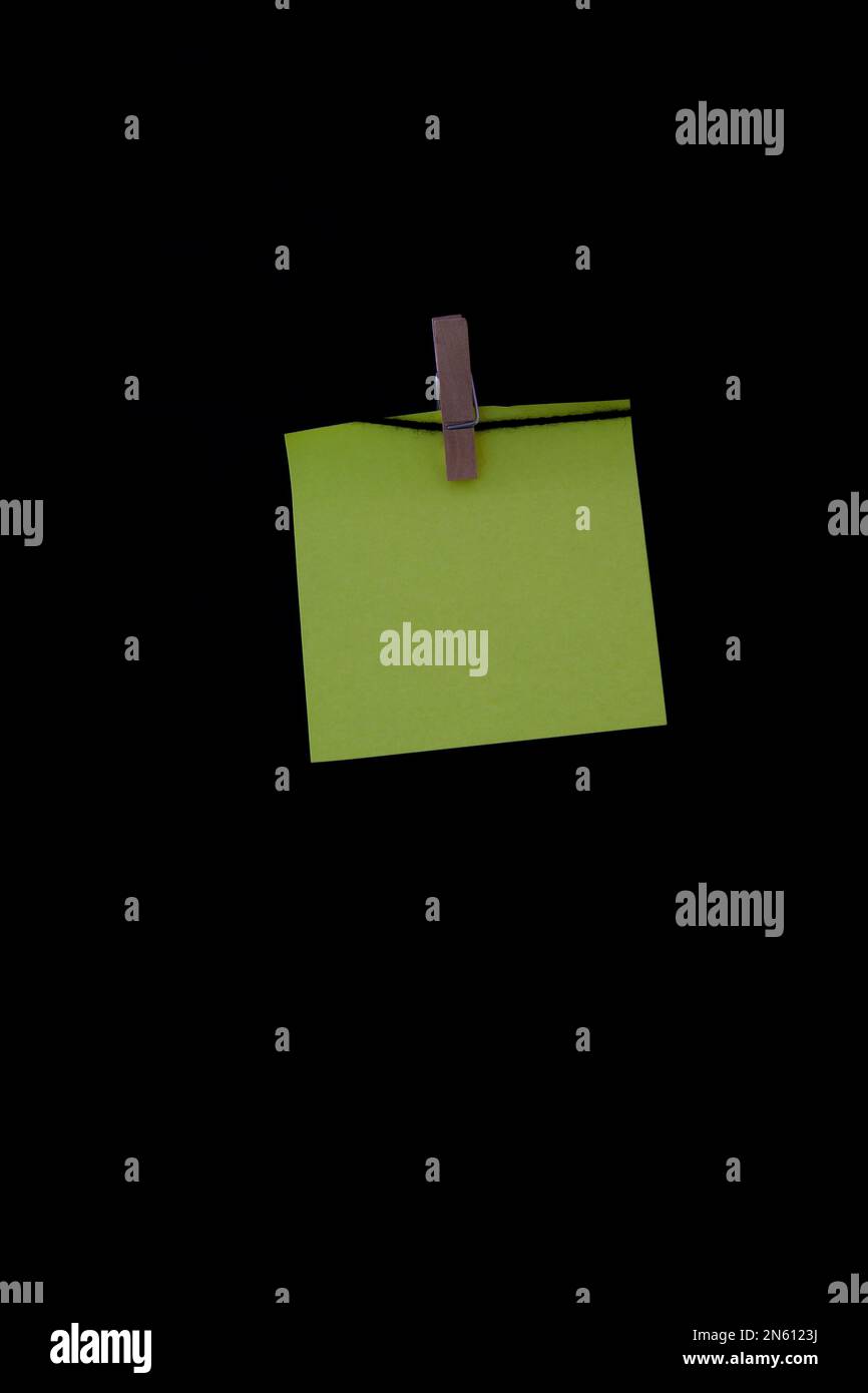 Yellow post it with wooden clothespin with dark background copy space ...