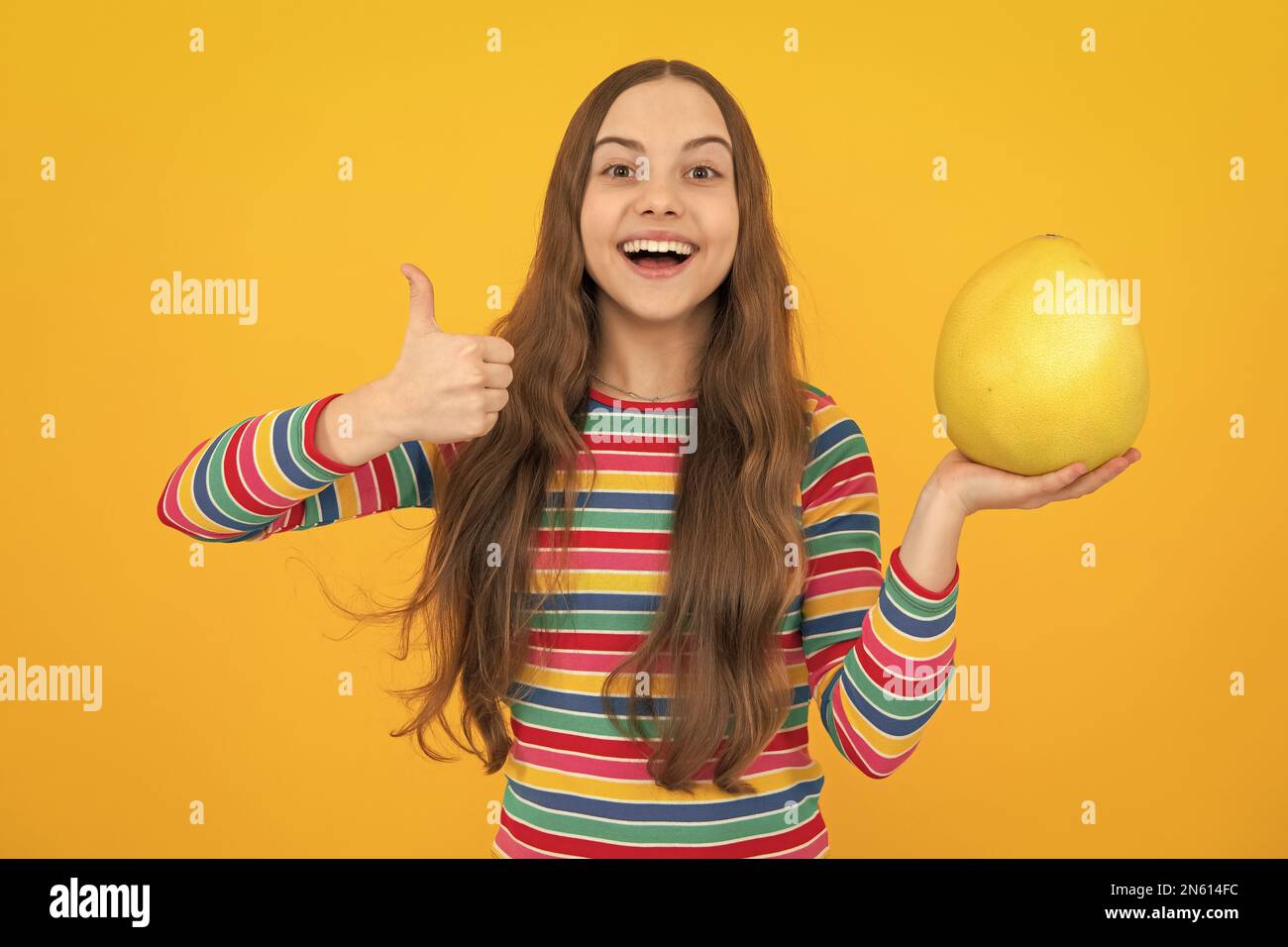 Teenager child girl hold citrus fruit pummelo or pomelo full of vitamin ...