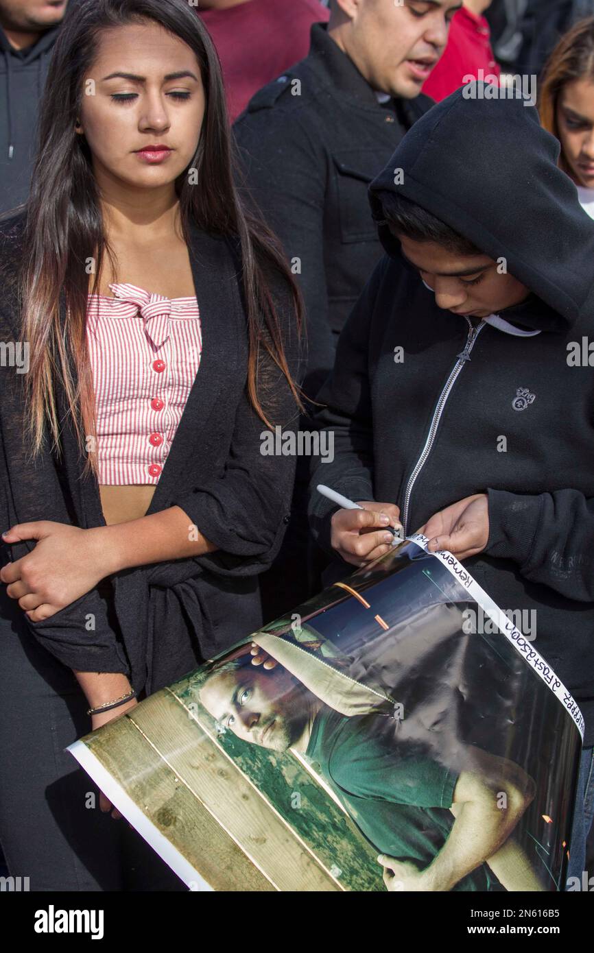 Nancy Gutierrez, left, looks on as her brother Freddie writes messages ...