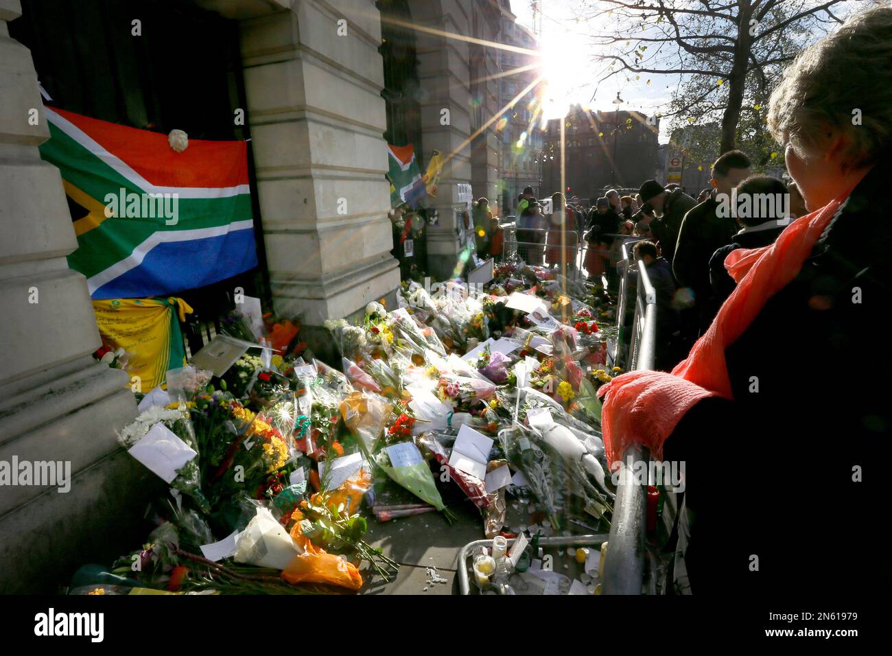 The sun shines as people look at the floral tributes left for Nelson ...