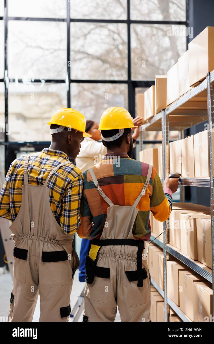 African american storehouse employees analyzing goods in stock using ...