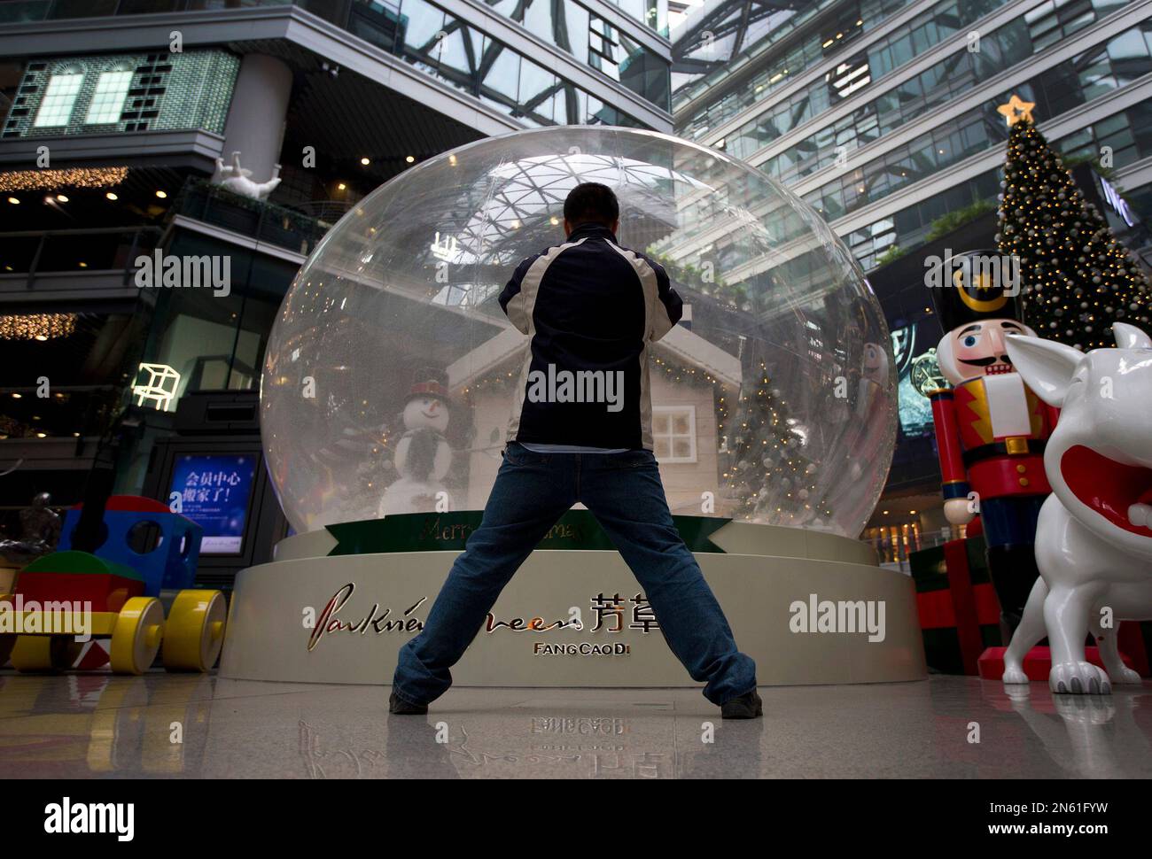 A man takes pictures of a huge crystal snowball on display with other ...