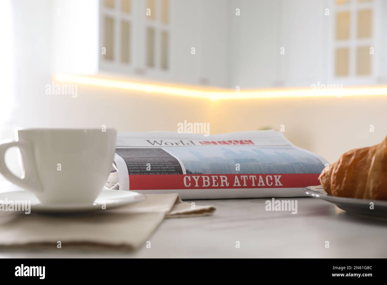 Newspaper with headline CYBER ATTACK, coffee and croissant on white ...