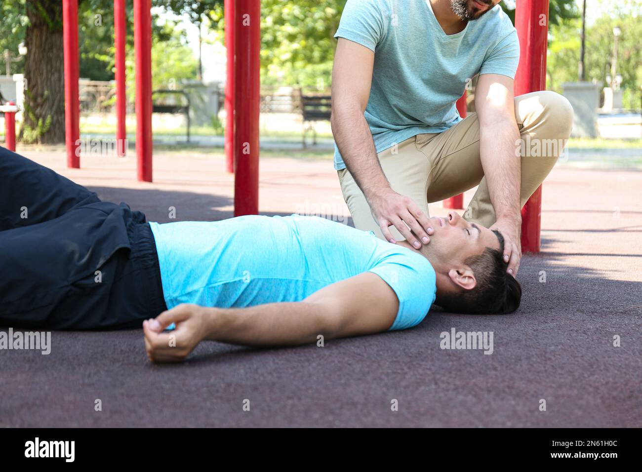 Passerby giving first aid to unconscious man outdoors Stock Photo - Alamy