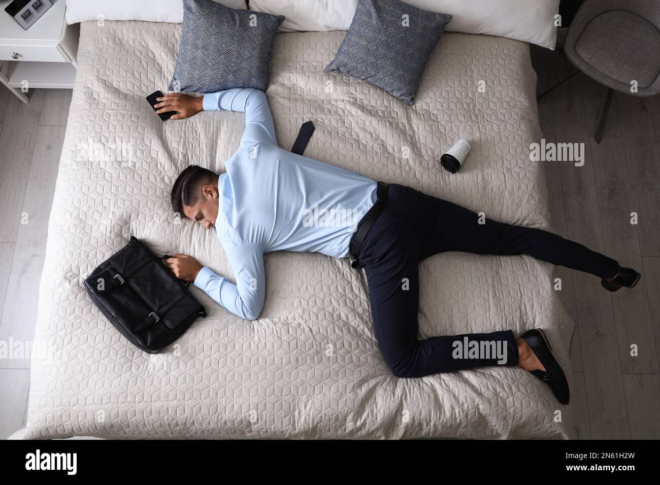 Exhausted businessman in office wear sleeping on bed at home after work ...