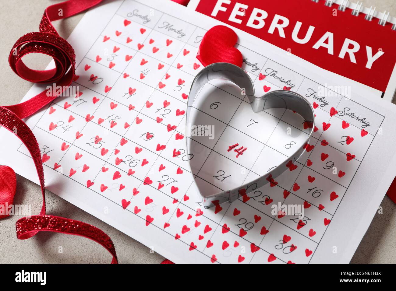 Calendar with marked Valentine's Day, red ribbon and heart shaped ...