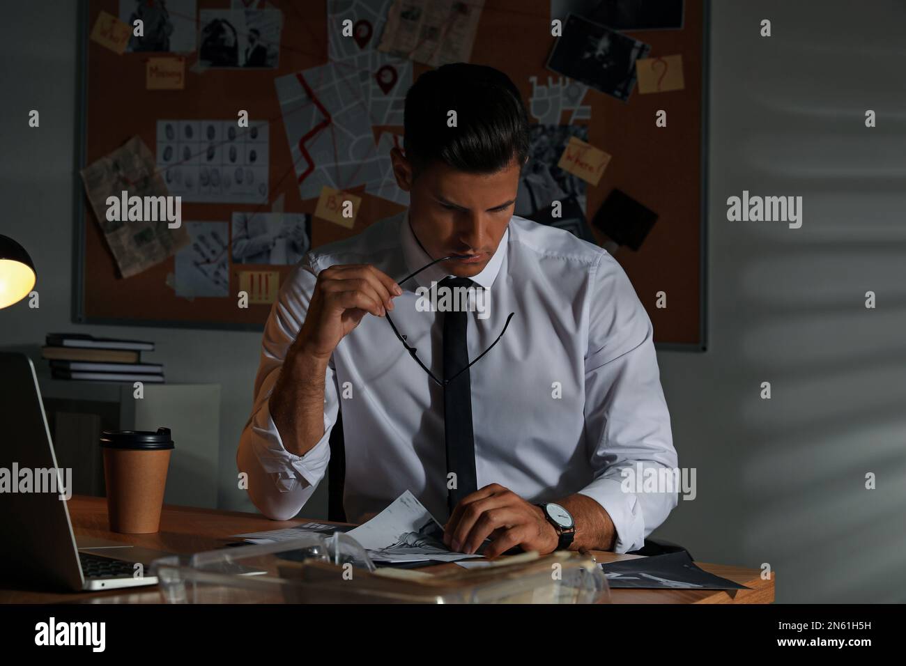 Detective working at desk in his office Stock Photo - Alamy