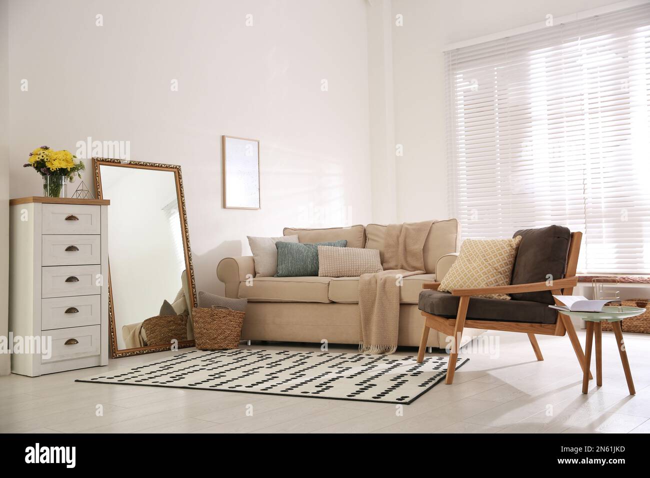 Large mirror and comfortable sofa in living room. Interior design Stock ...