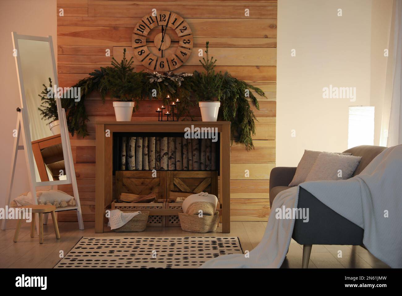 Cozy room interior with console table and conifer garland near wooden ...