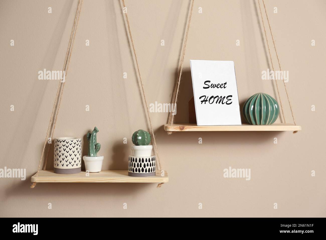 Wooden shelves with different decorative elements on beige wall Stock ...