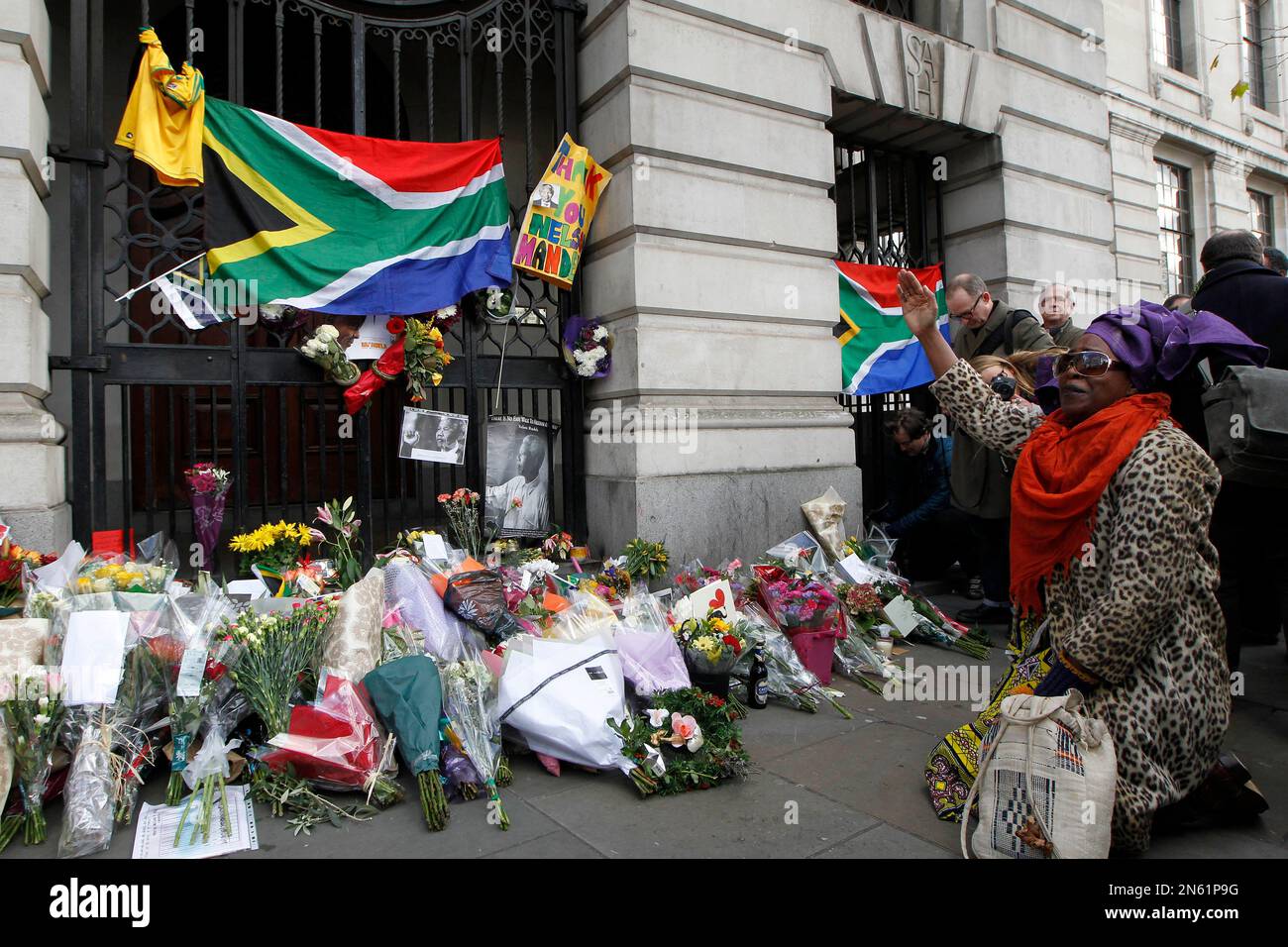 A woman mourns for Nelson Mandela after placing a floral tribute ...