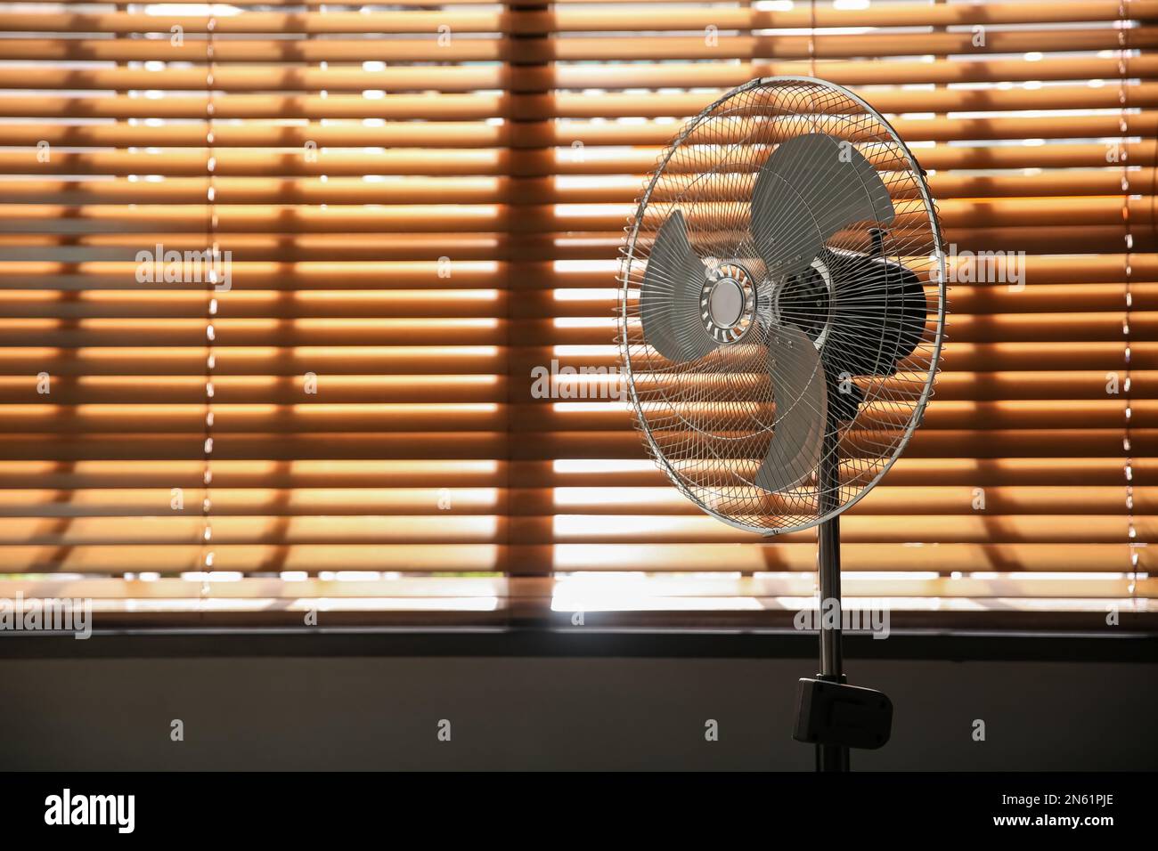 Modern electric fan near window indoors. Space for text Stock Photo - Alamy