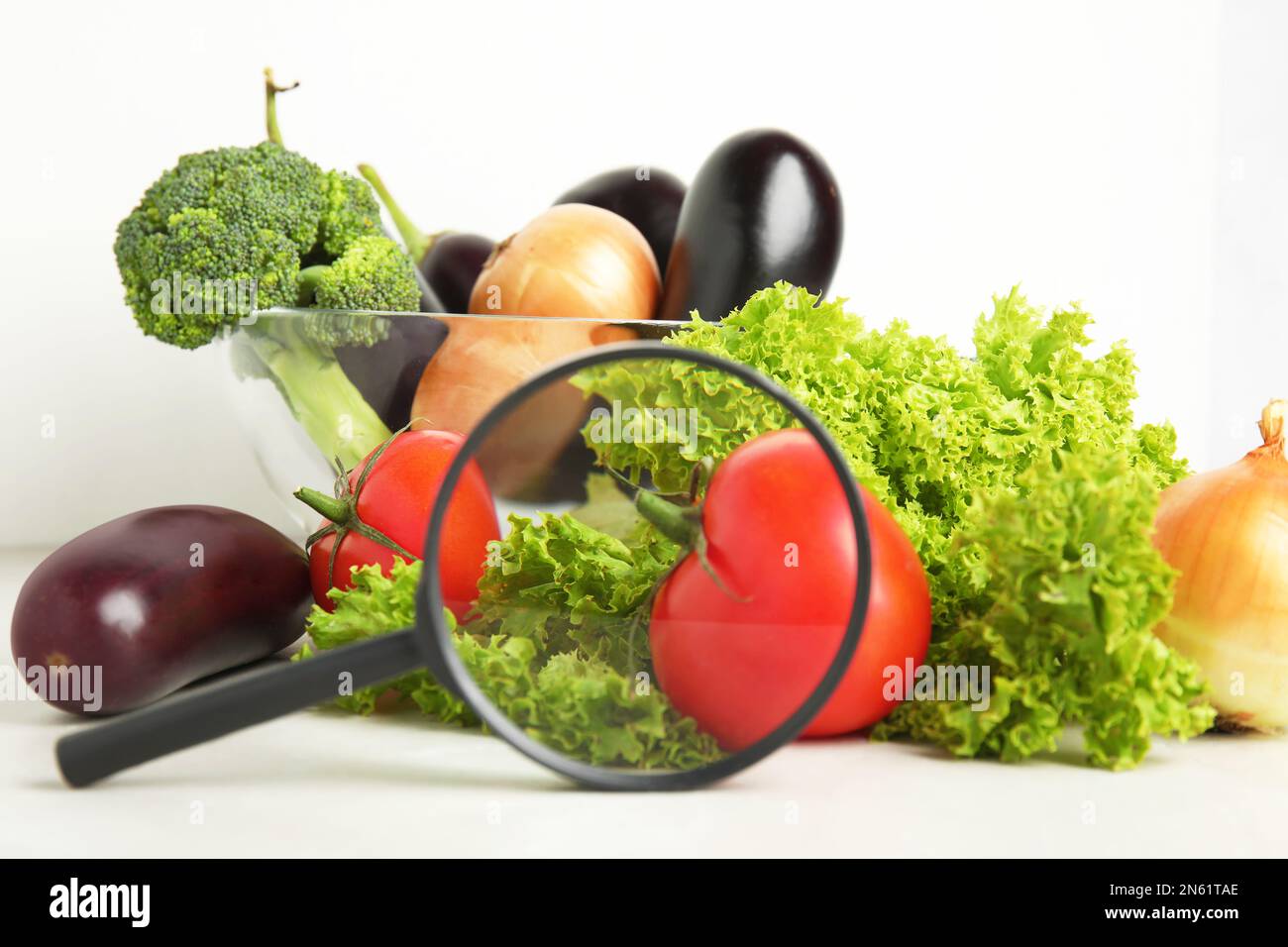 Different fresh vegetables and magnifying glass on table. Poison ...