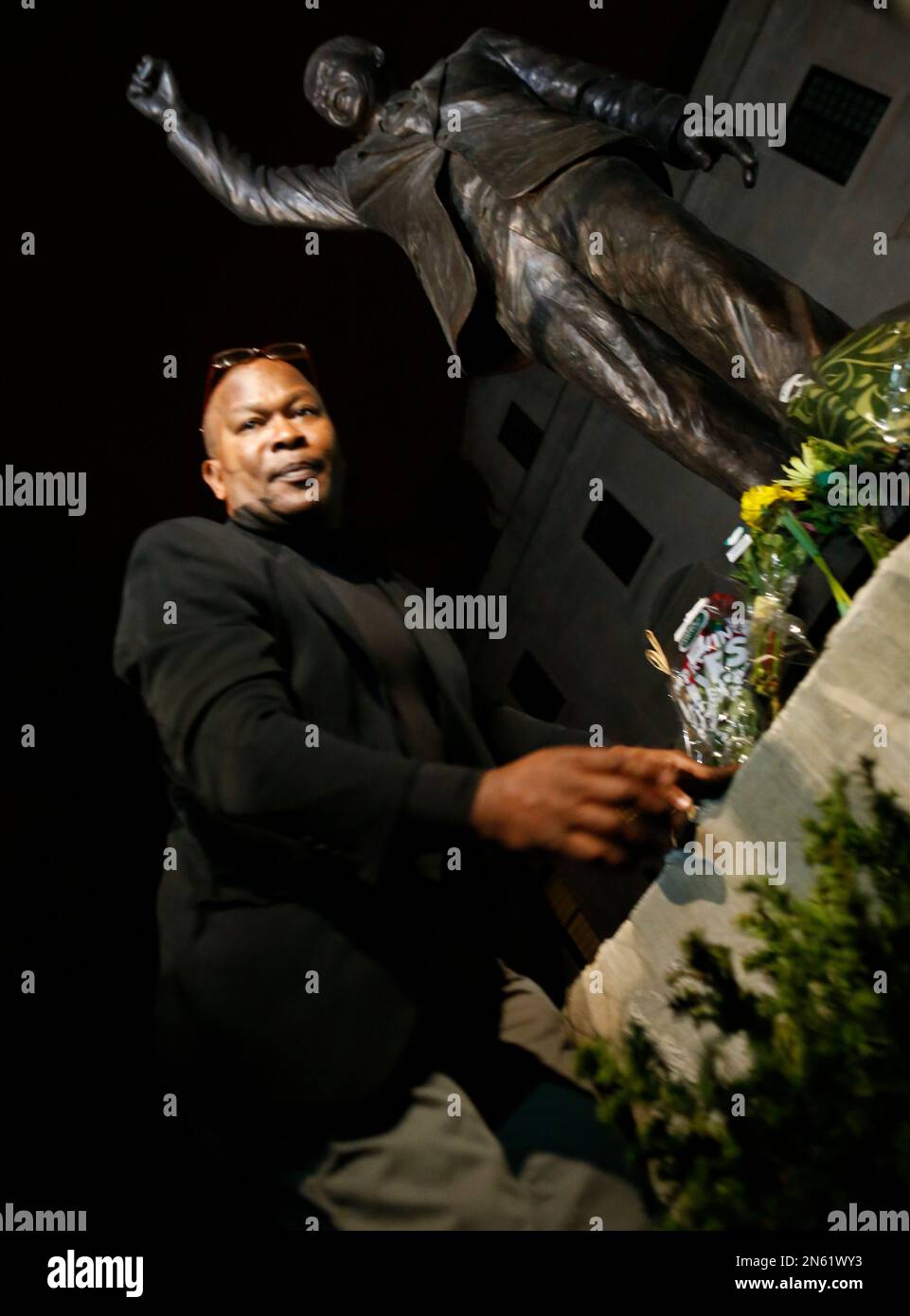 Peter Boyce of Washington, D.C., places a candle at the foot of a ...
