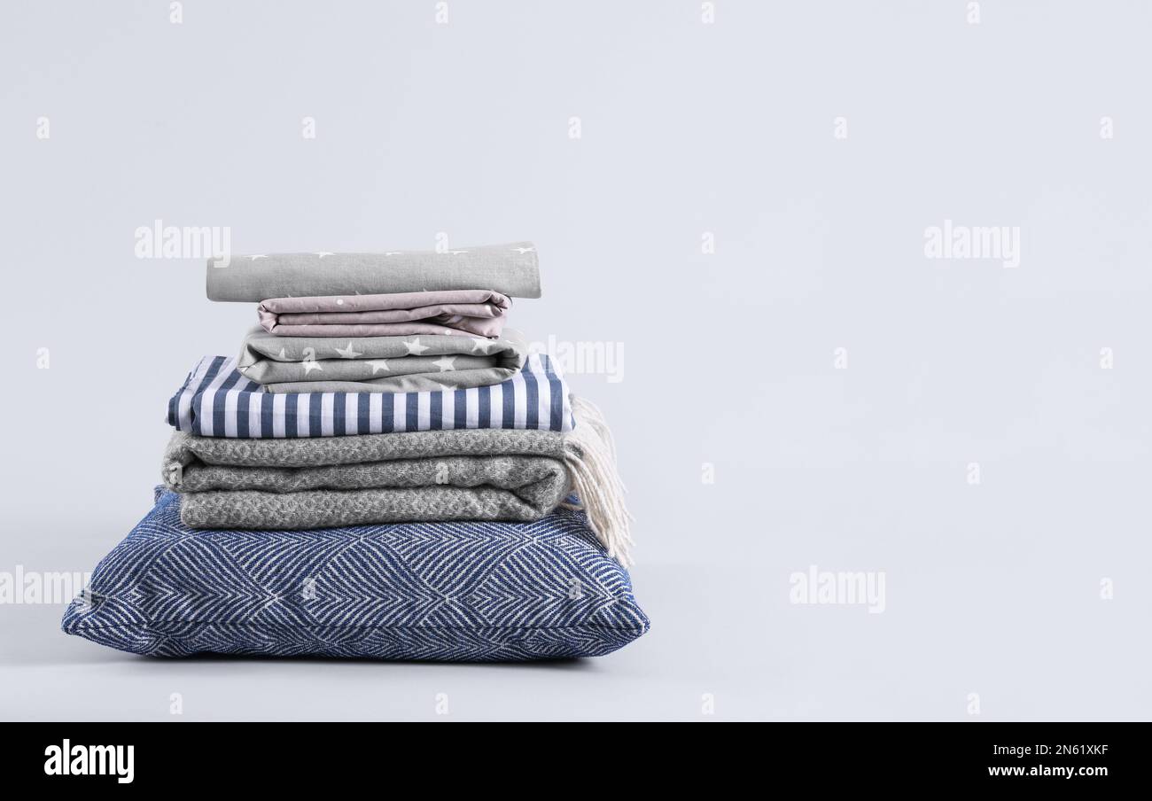 Stack of clean bed sheets and pillow on white background Stock Photo ...