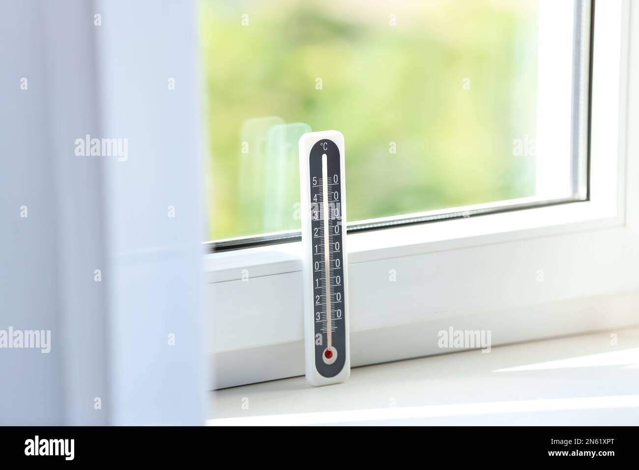 Grey weather thermometer on window sill indoors Stock Photo - Alamy