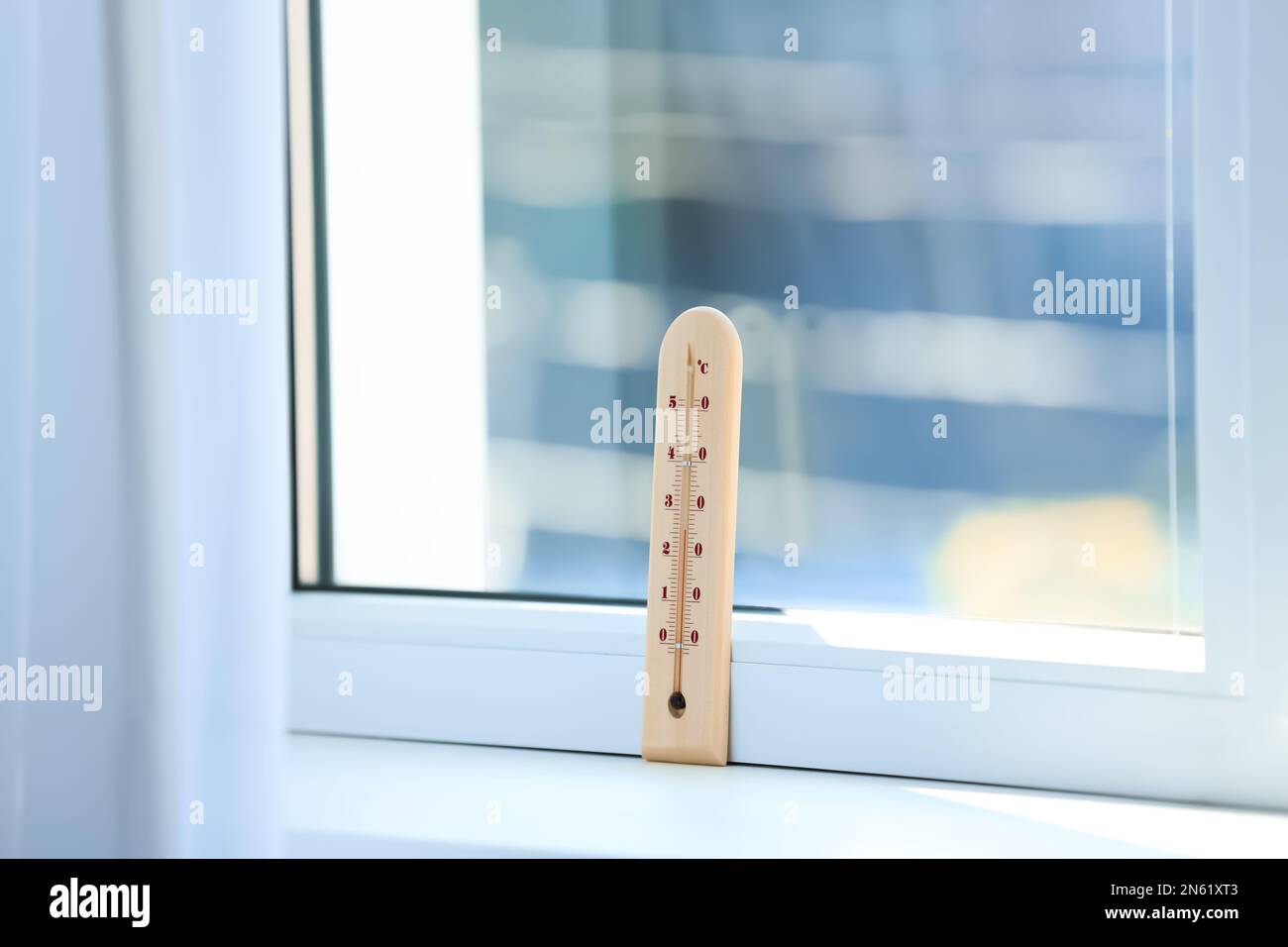 Wooden weather thermometer on window sill indoors Stock Photo - Alamy