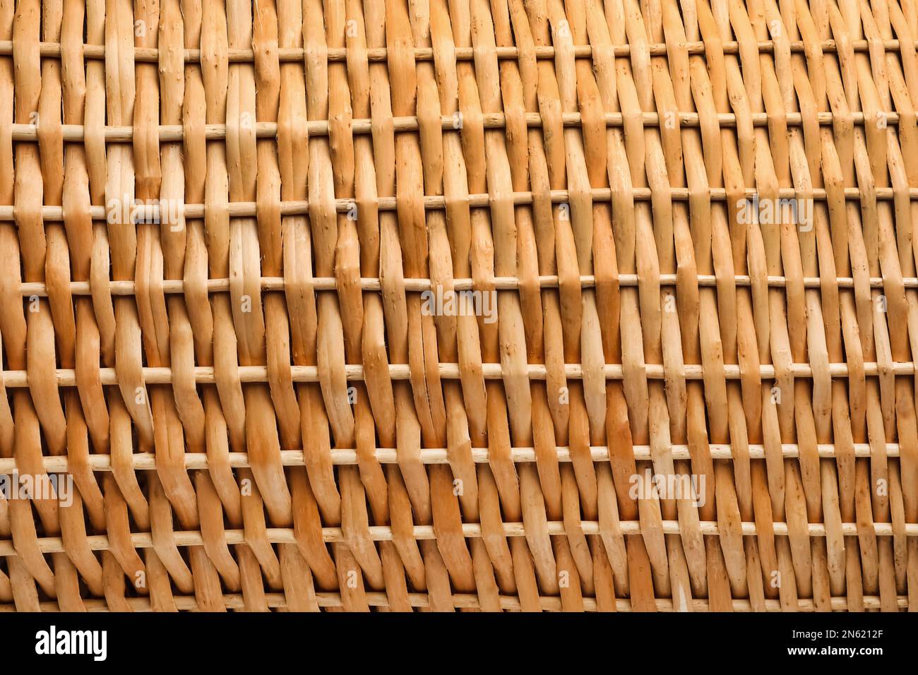 Handmade wicker basket made of natural material as background, closeup ...
