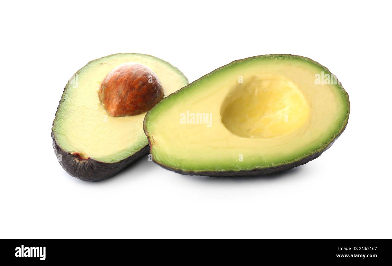 Cut ripe avocado with pit on white background Stock Photo - Alamy