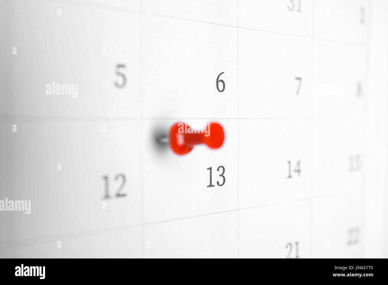 Calendar page with pin on Friday 13, closeup. Bad luck superstition ...