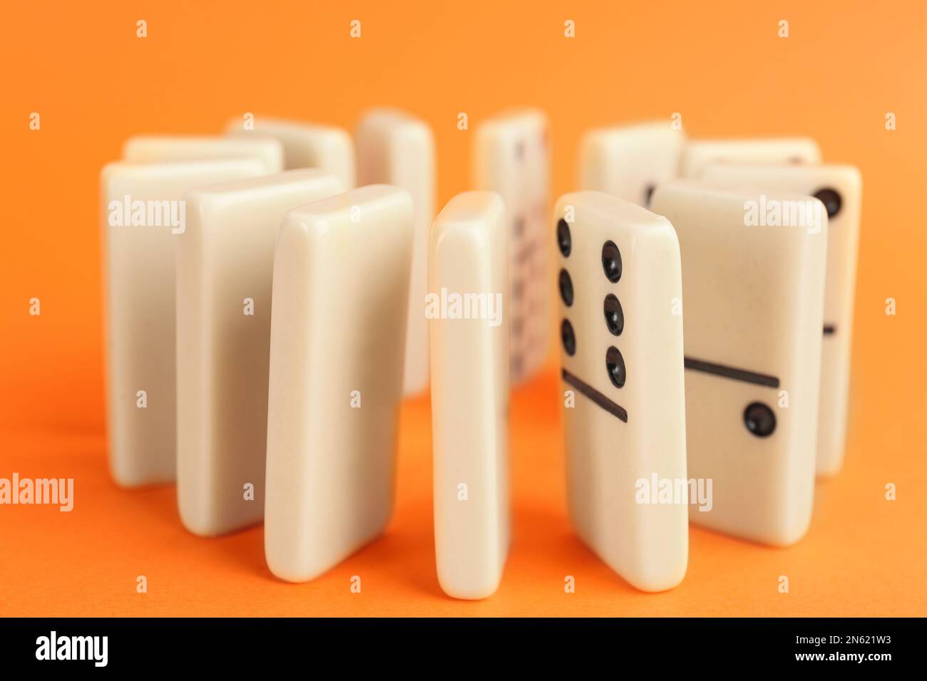 White domino tiles with black pips on orange background Stock Photo - Alamy