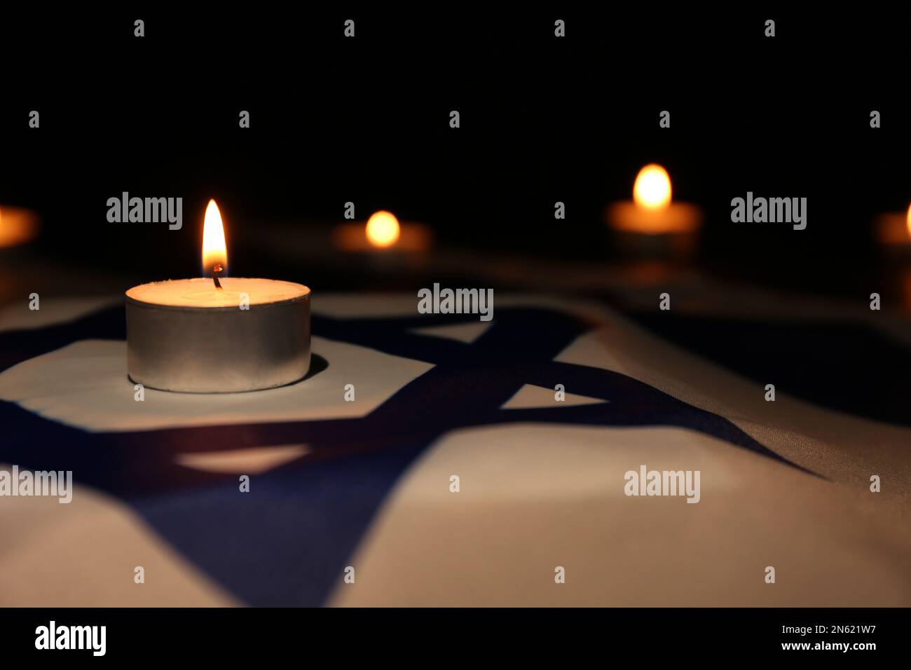 Burning candle on flag of Israel. Holocaust memory day Stock Photo - Alamy