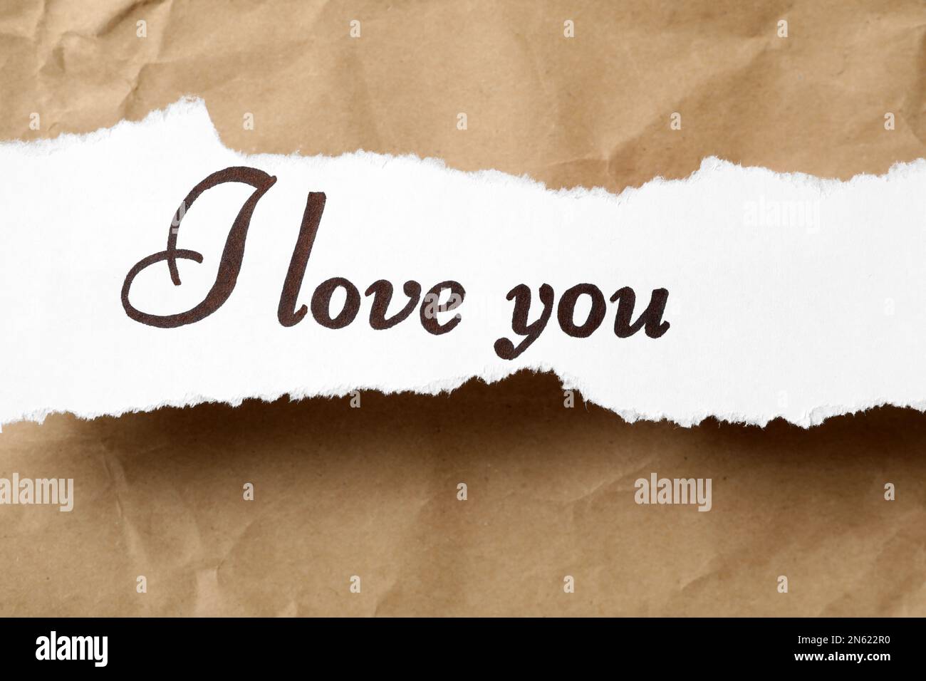 Torn sheet of paper with text I Love You on crumpled beige background ...