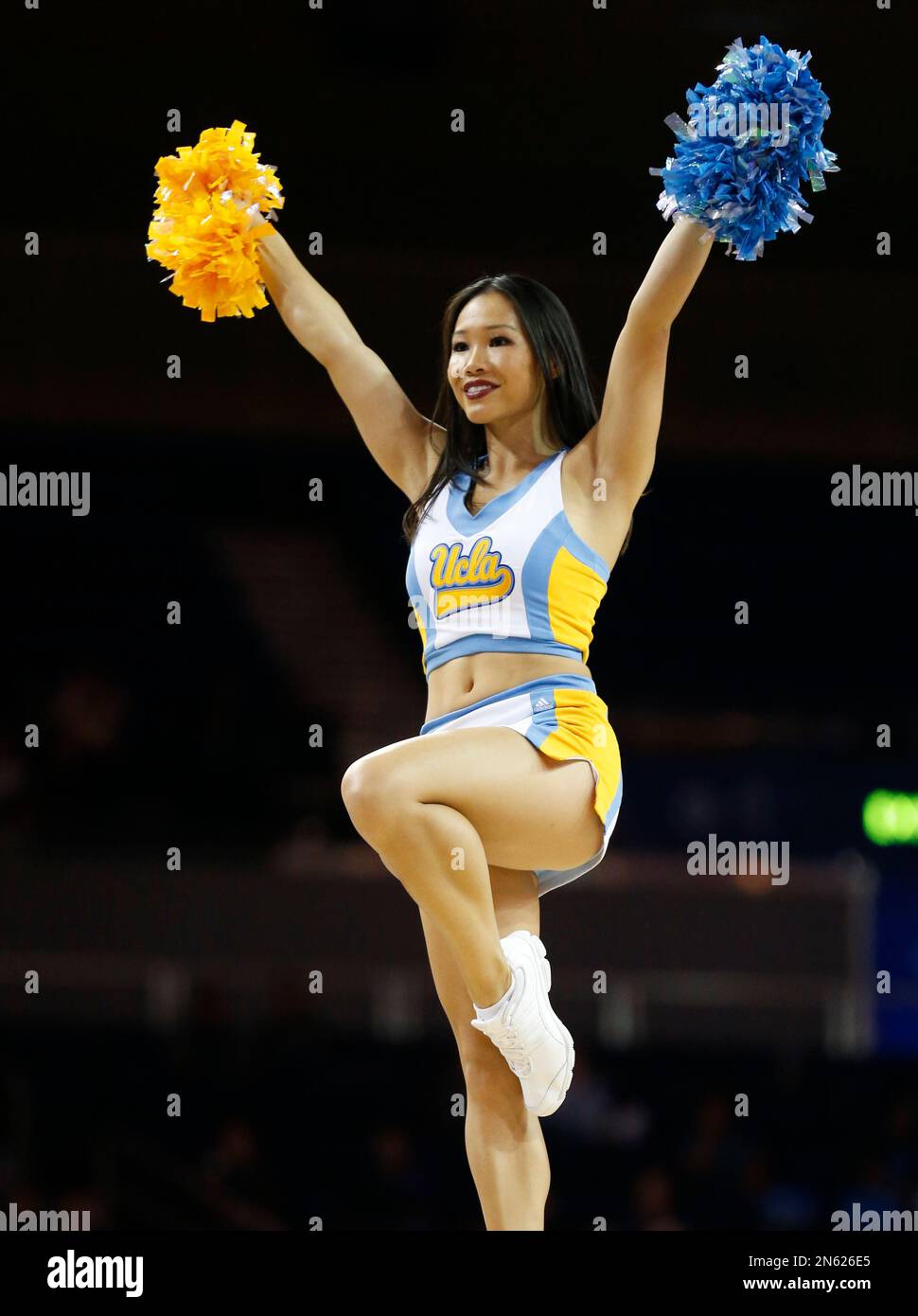 A UCLA cheerleader performs as their hair flies against UC Santa ...