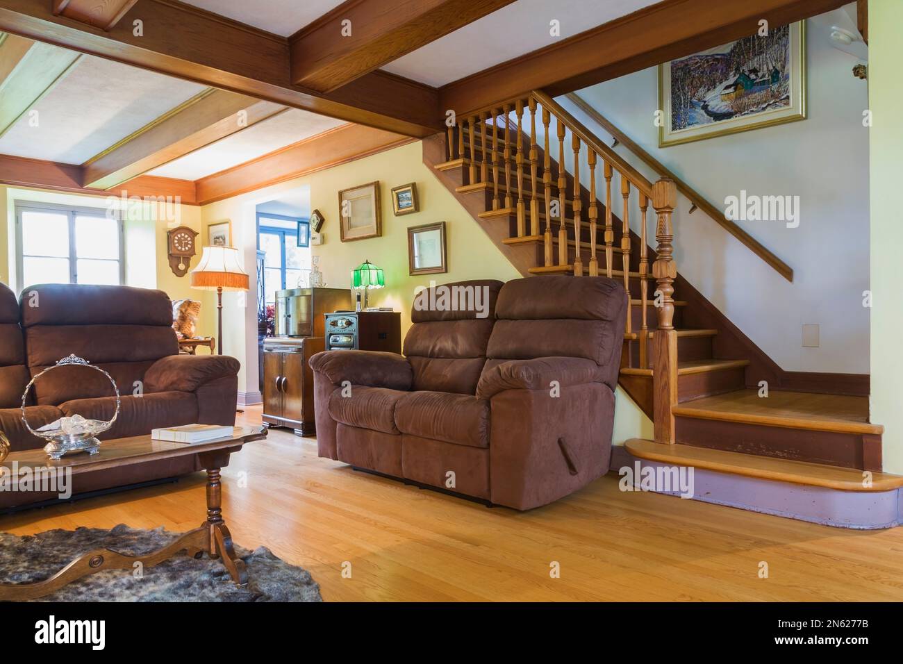 Brown upholstered sofas in living room with wooden coffee table on top ...