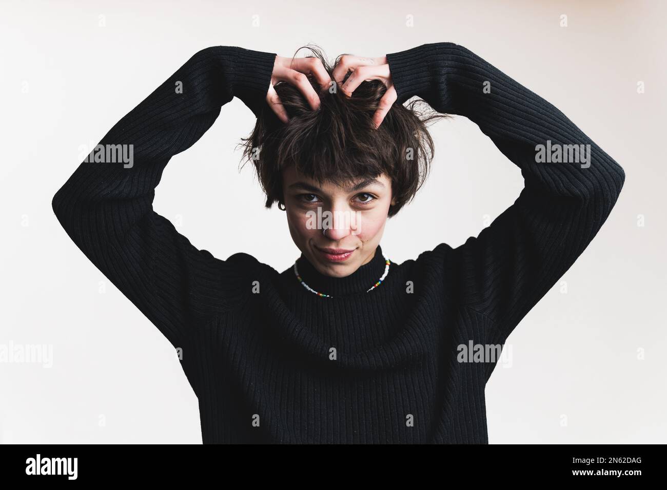 Studio portrait of confident unusual young adult woman touching ruffled ...