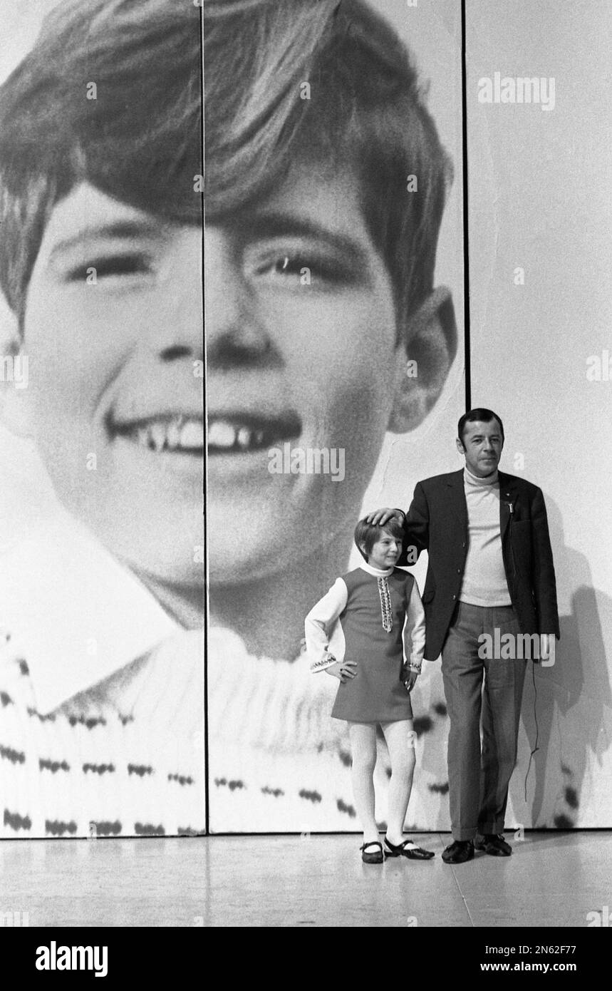 Standing in front of a giant photograph of Dutch child singer and actor ...