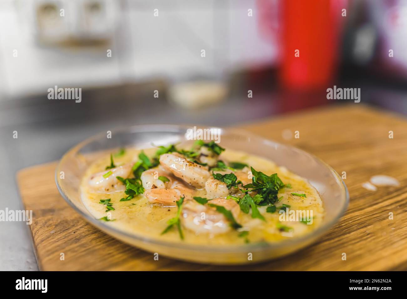 Shrimps in spicy chilli sauce on transparent platter ready for serving ...